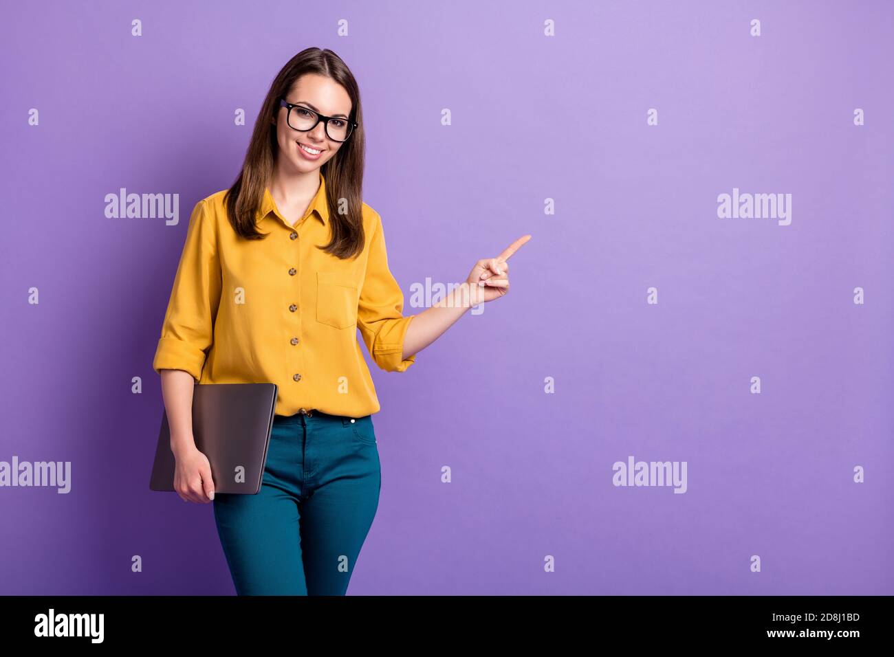 Photo of cute lady hold computer direct finger empty space wear glasses ...