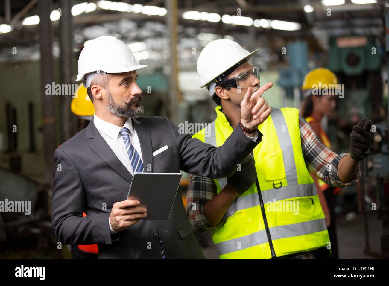 Male Industrial Engineers Talk with Factory Worker . They Work at the ...