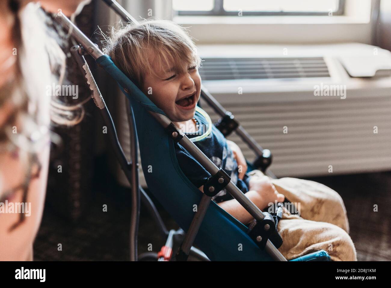 Young toddler boy crying in his stroller in hotel room in Palm Springs ...