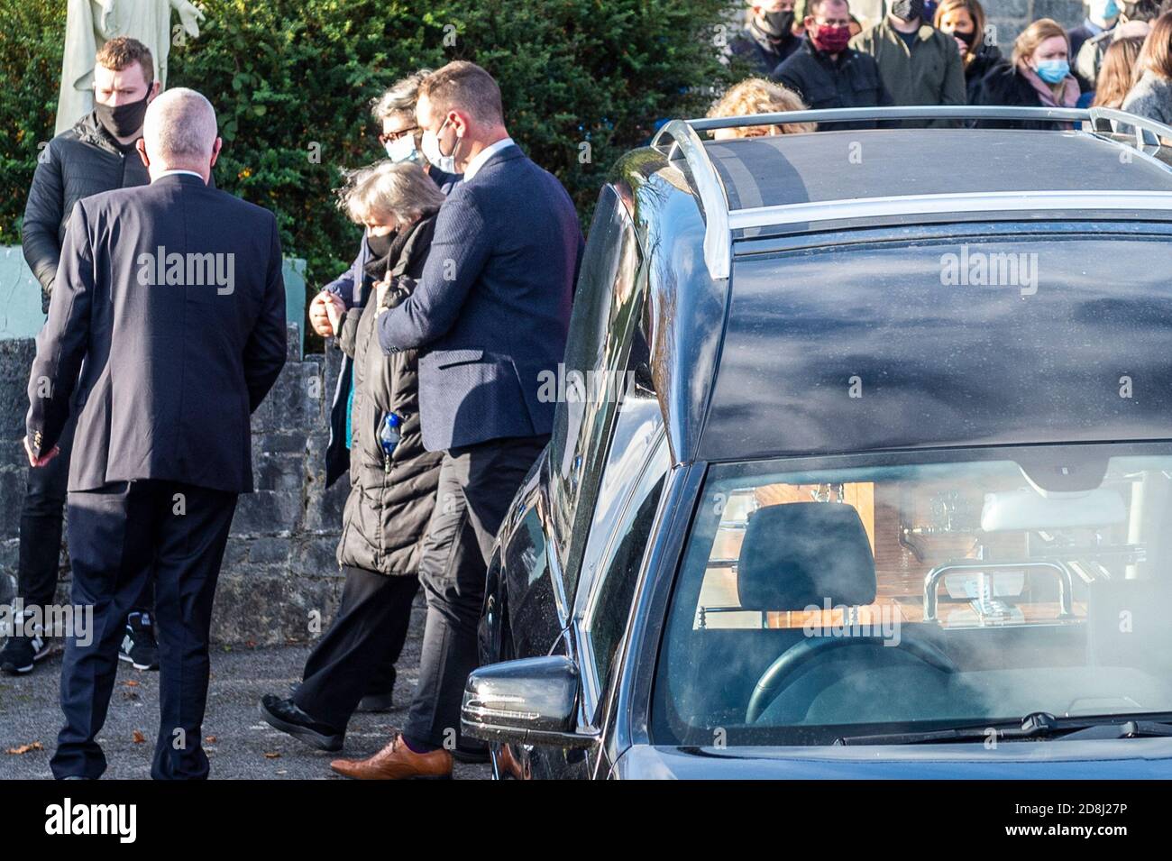 The wife and mother, Anne O'Sullivan, is supported as she walks past ...