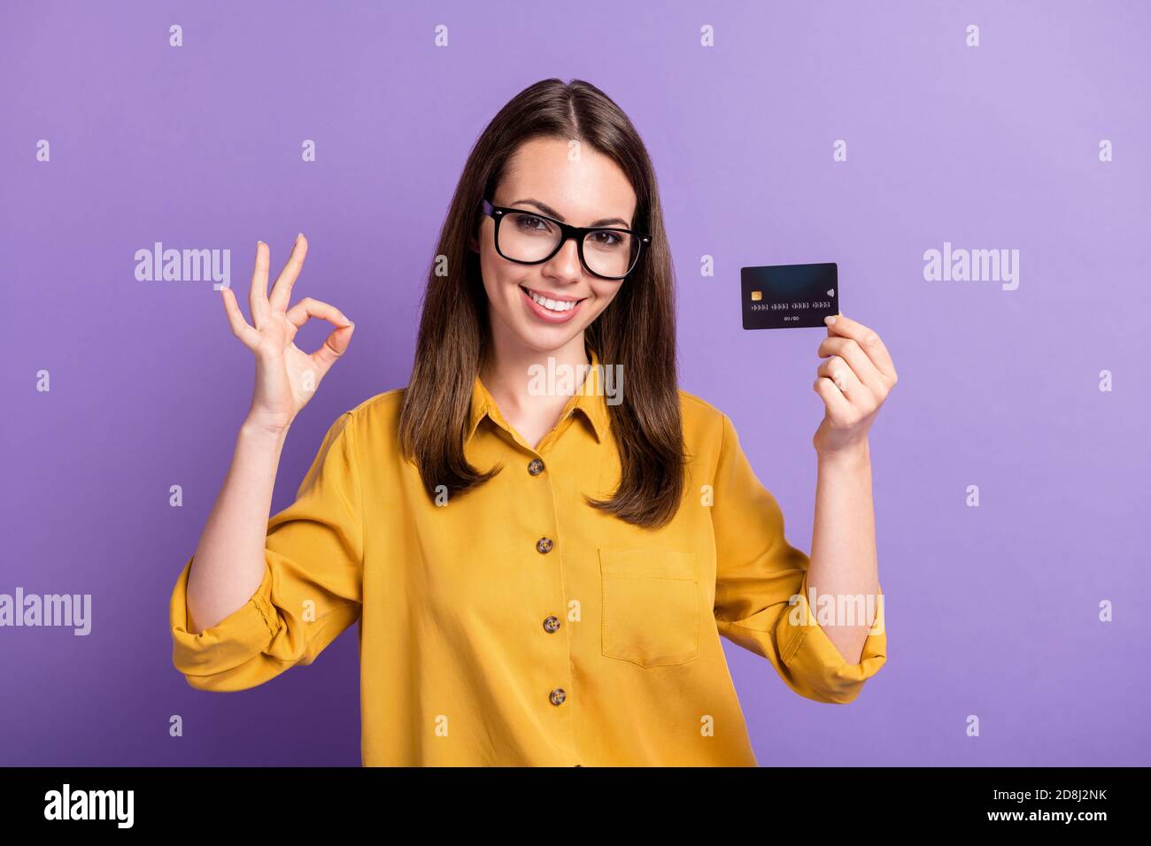 Photo of young lady raise hand show okey hold debit card toothy smile ...