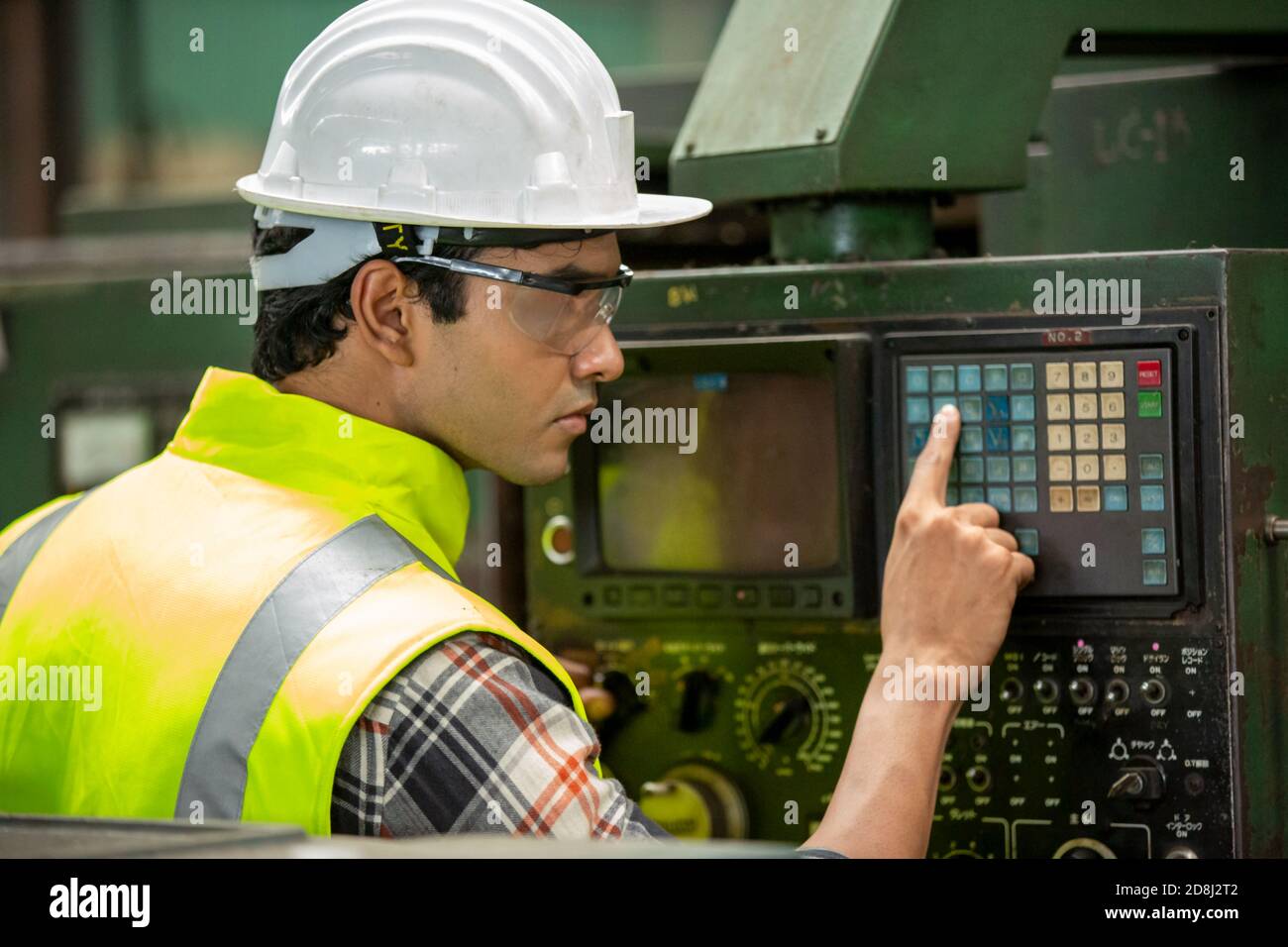 Engineers operating a cnc machine in factory Stock Photo - Alamy