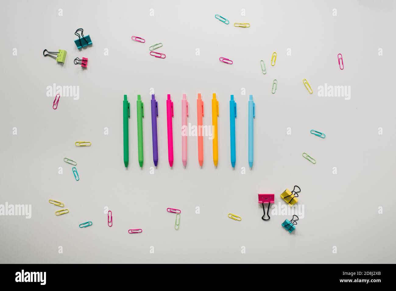 Rainbow pens and paper clips on white background Stock Photo - Alamy