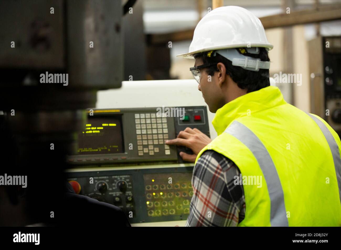 Engineers operating a cnc machine in factory Stock Photo - Alamy