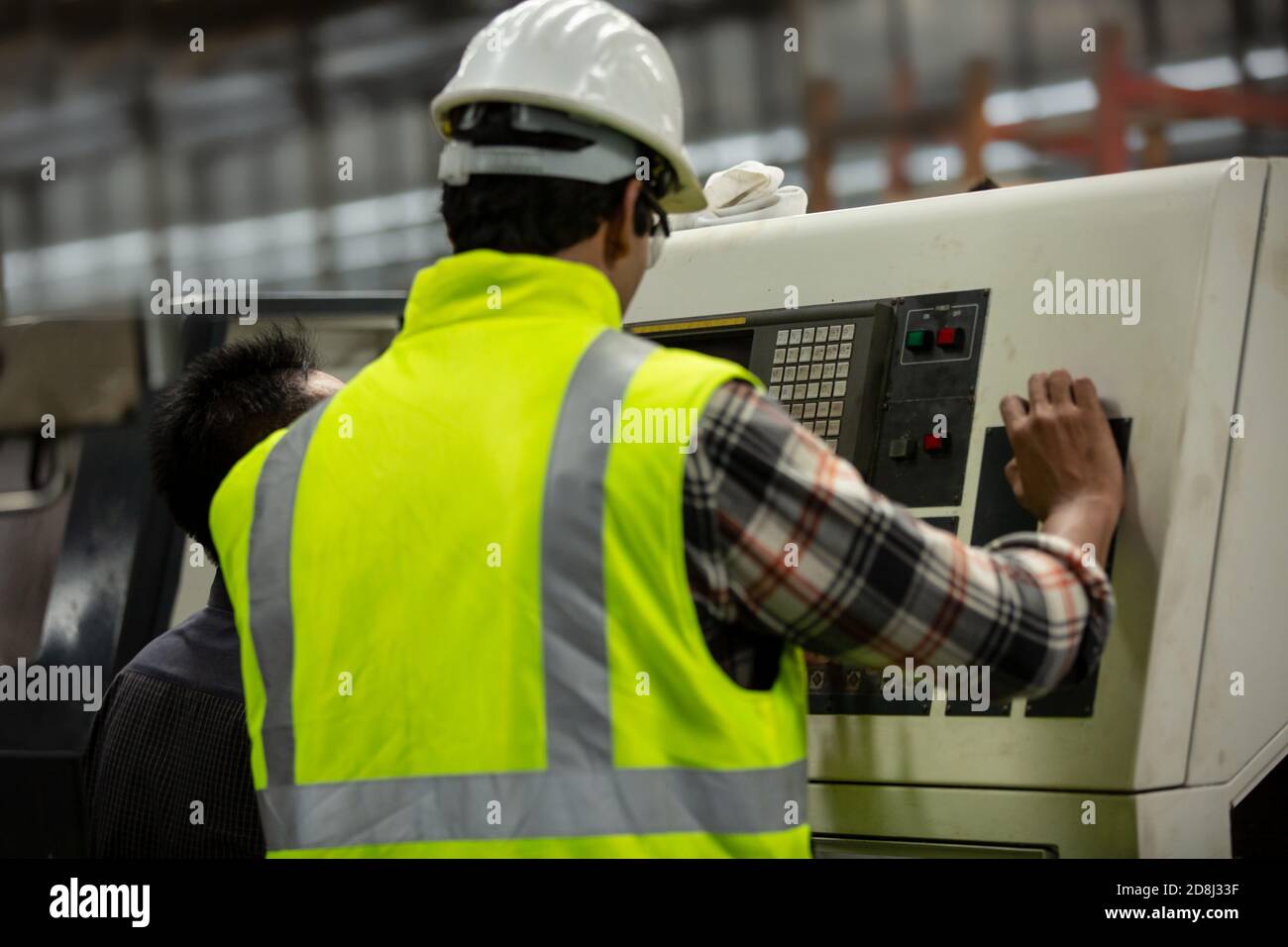 Engineers operating a cnc machine in factory Stock Photo - Alamy