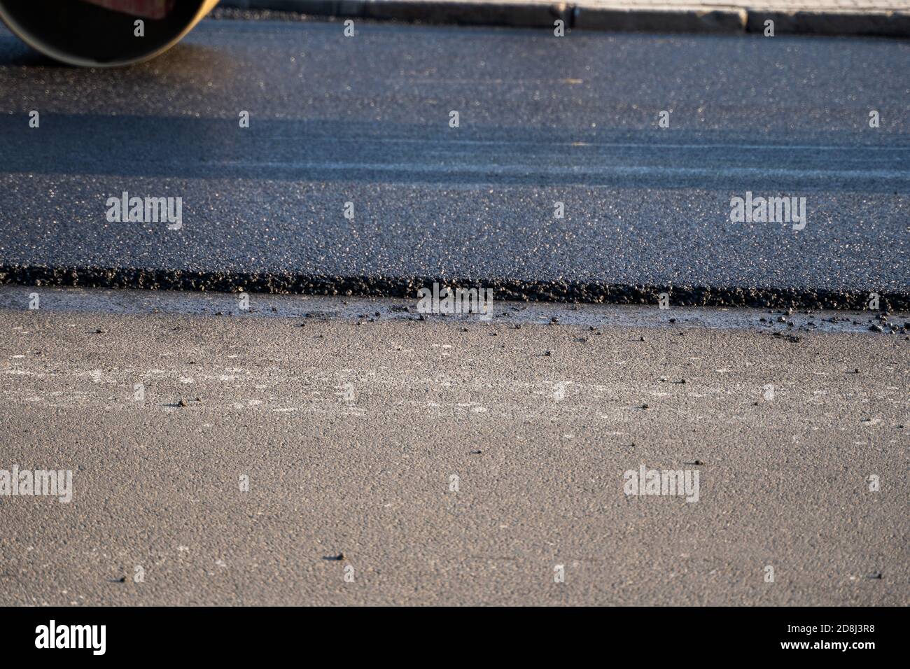 Freshly laid black bitumen asphalt with a high edge to the gravel ...