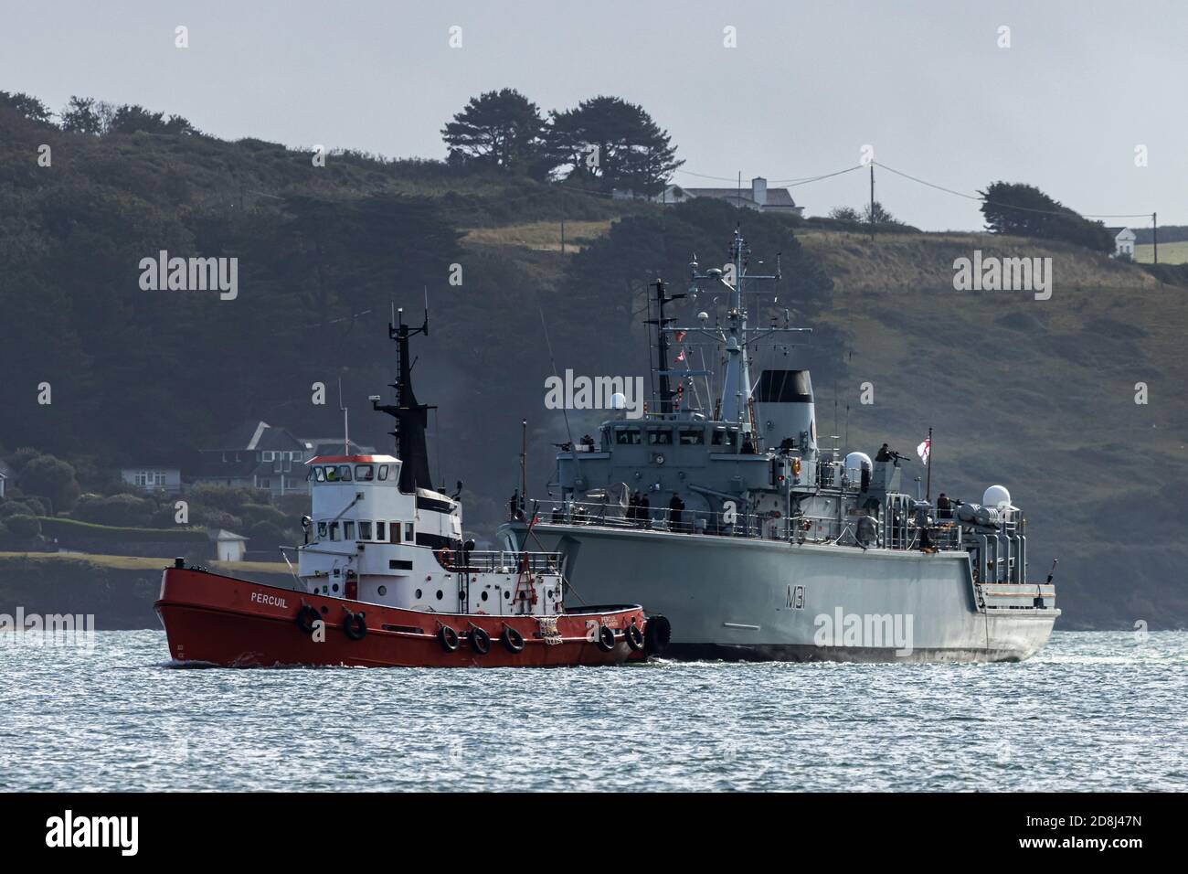 A tug towing a navy boat Stock Photo - Alamy