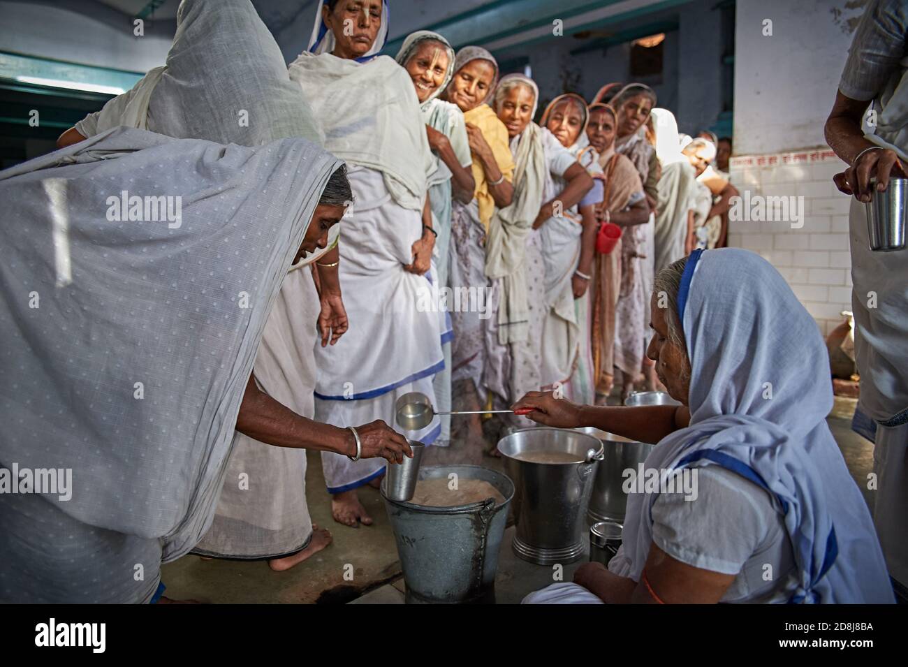 Vrindavan, India, August 2009. Widows standing in line inside an ashram ...