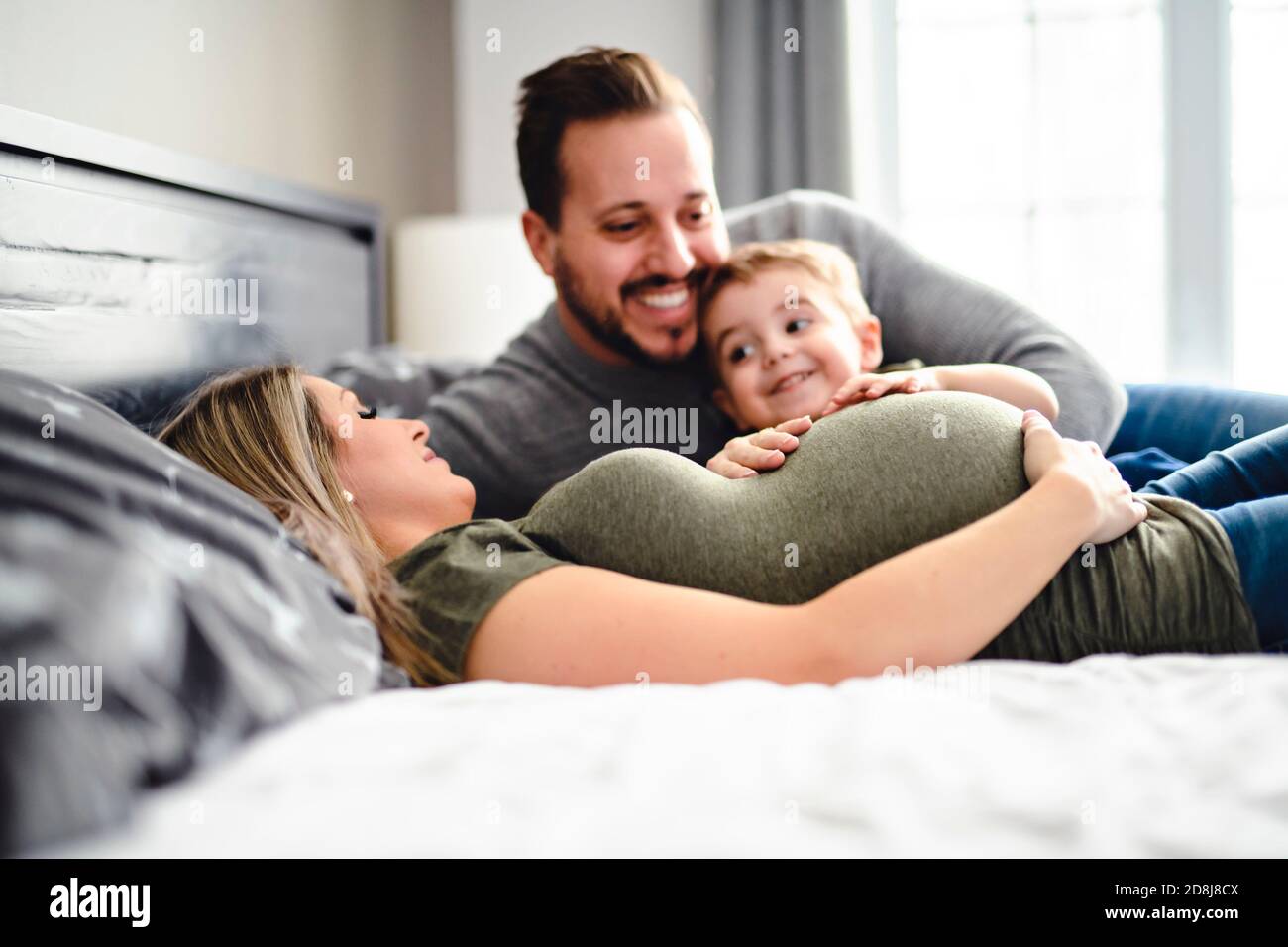 father, son and pregnant mother at home. Beautiful loving family ...