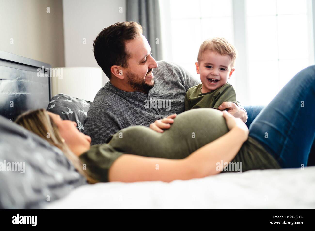 father, son and pregnant mother at home. Beautiful loving family ...