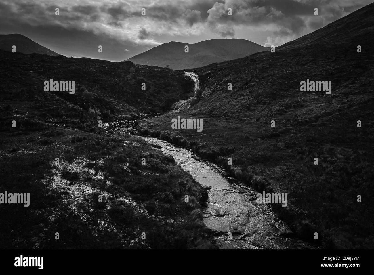 A nature landscape with a waterfall under a stormy sky in the Isle of ...