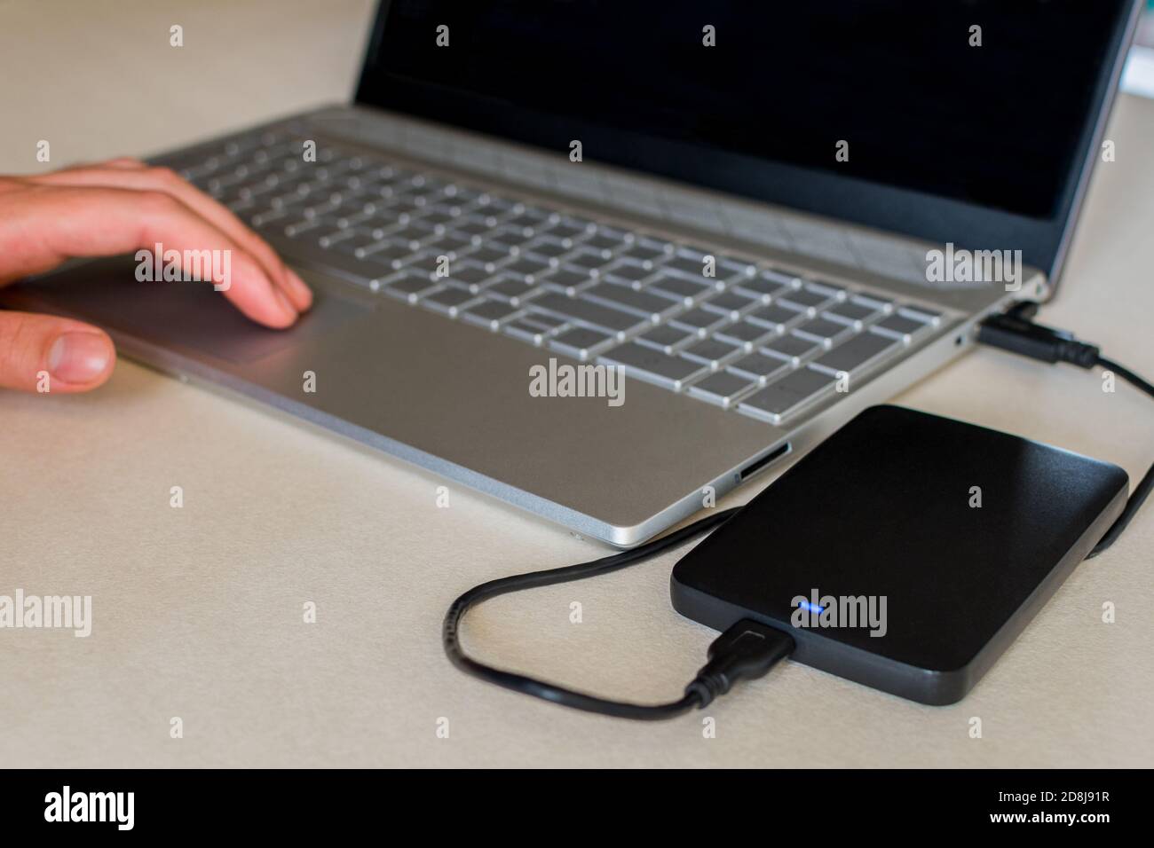 Portable hard drive connected to a laptop - concept of data storage ...