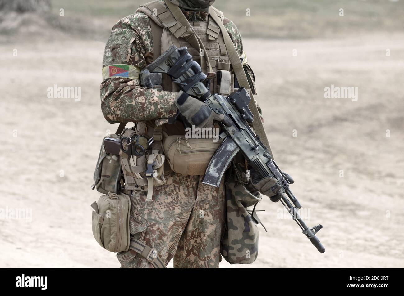 Soldier with assault rifle and flag of Eritrea on military uniform ...