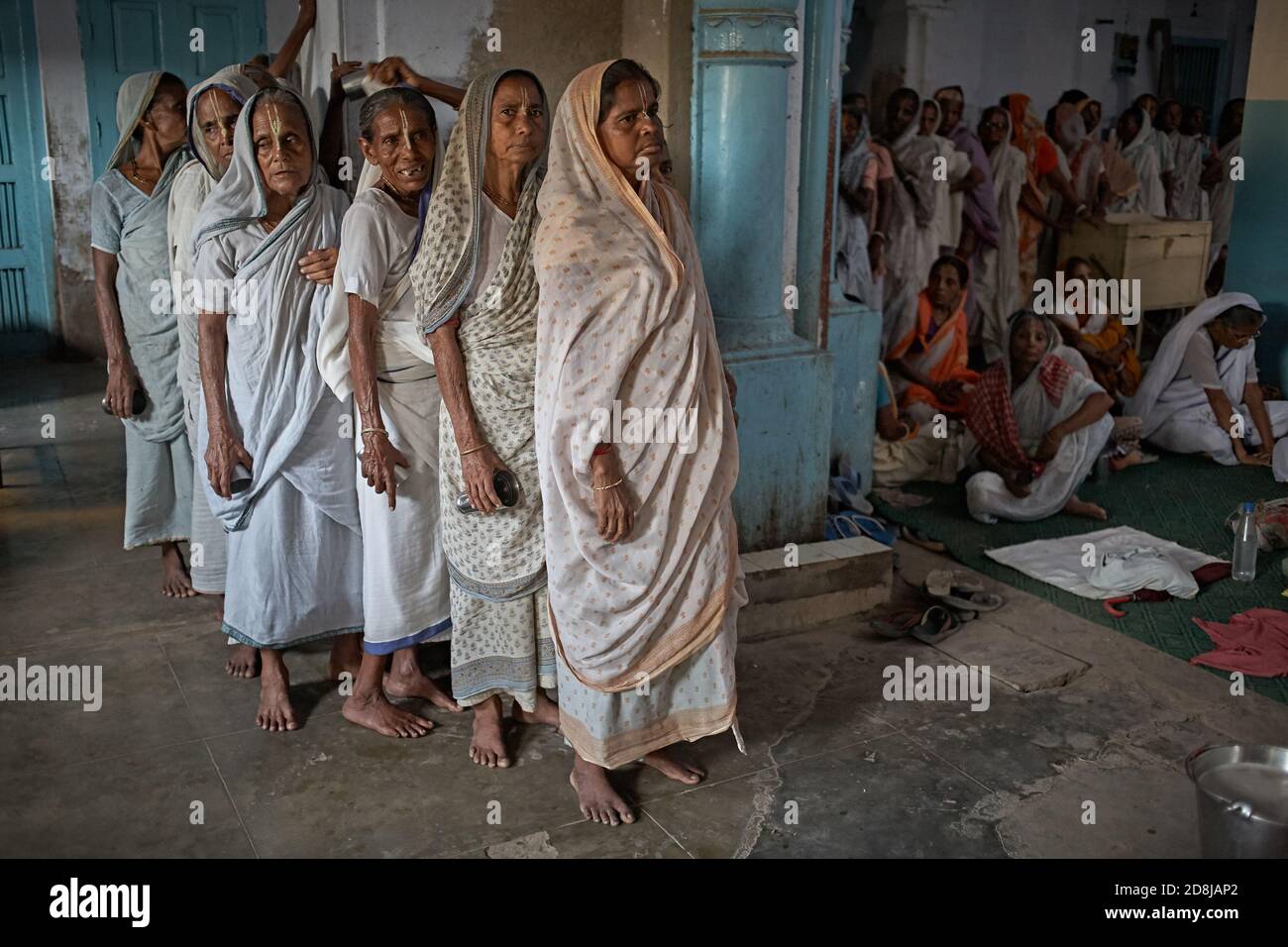Vrindavan, India, August 2009. Widows standing in line inside an ashram ...