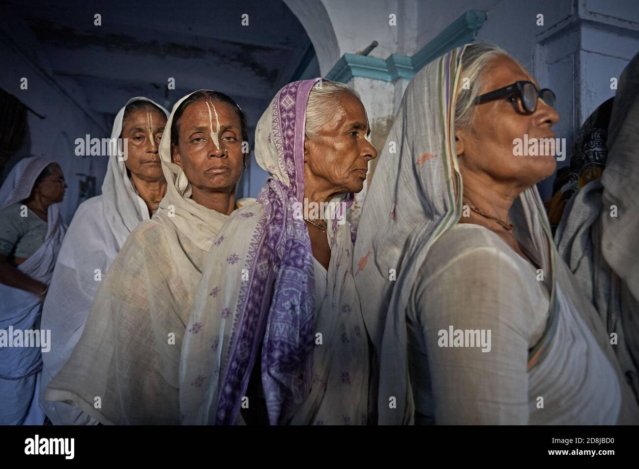 Vrindavan, India, August 2009. Widows standing in line inside an ashram ...