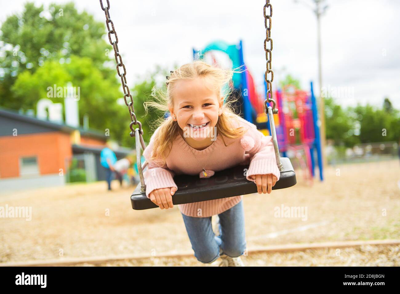 girl on the playground swing on the school day Stock Photo - Alamy