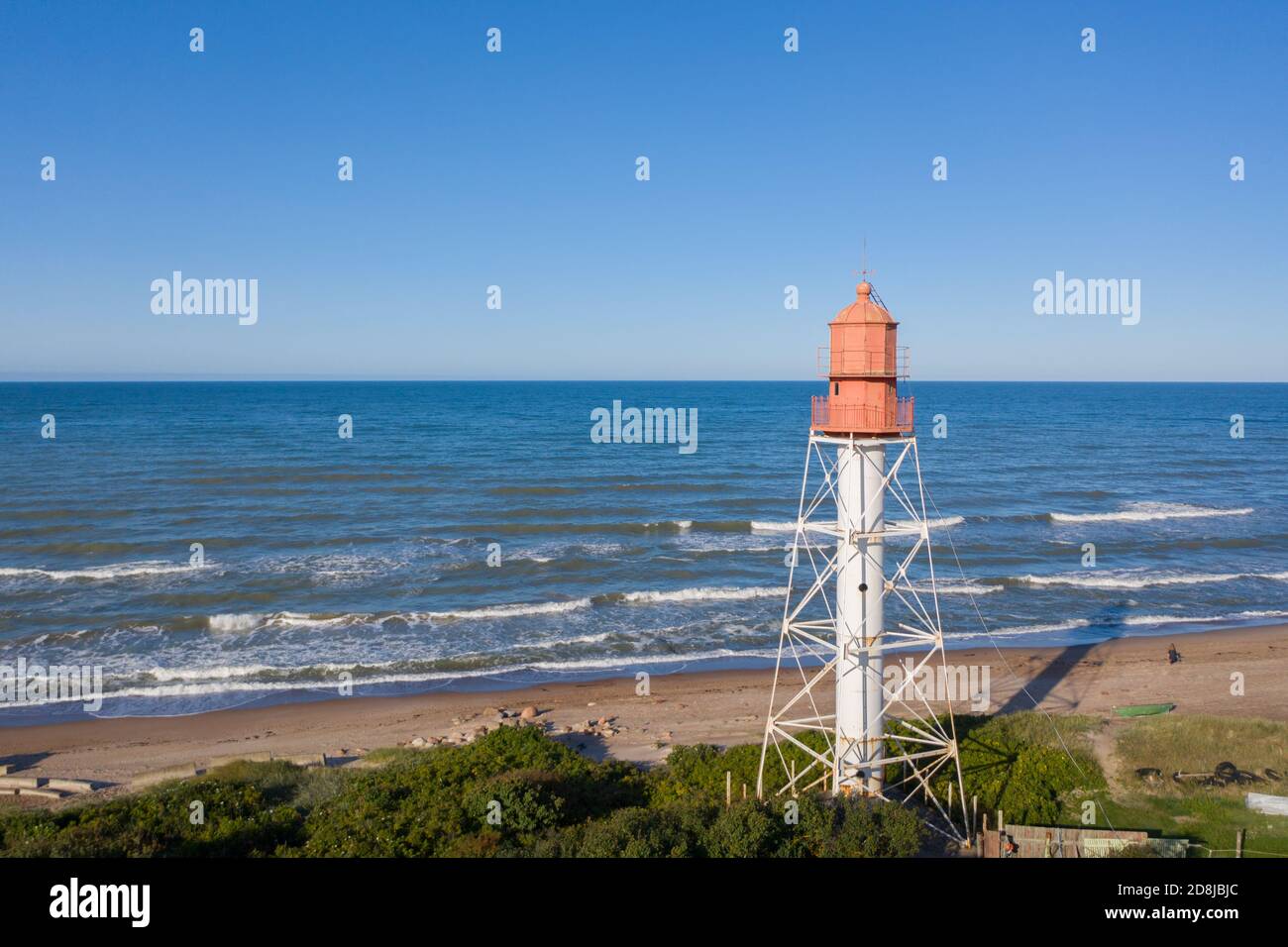 Aerial view of lighthouse with red top and white base. Blue sky and sea ...