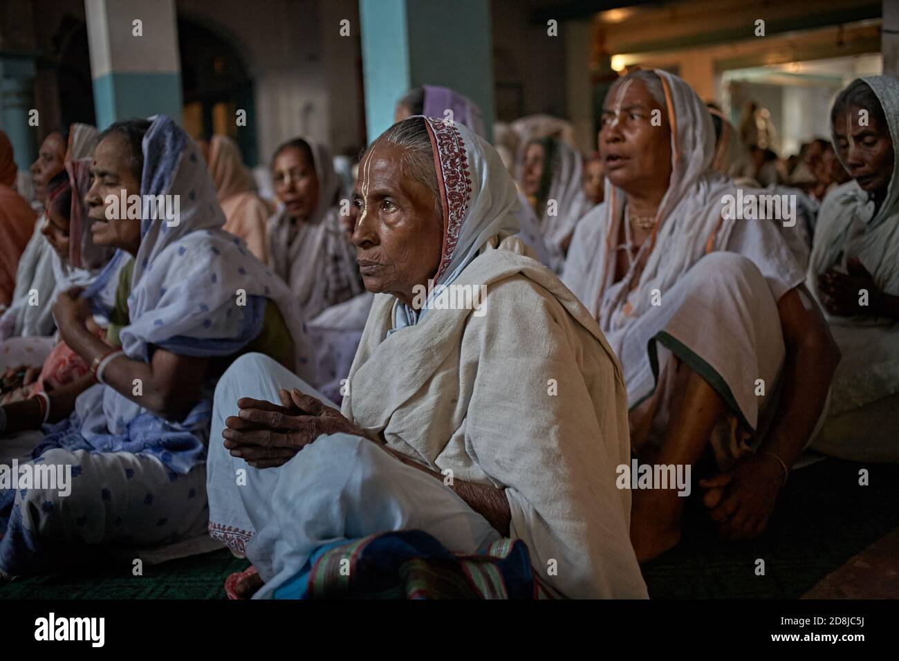 Vrindavan, India, August 2009. Widows gathered to pray inside an ashram ...