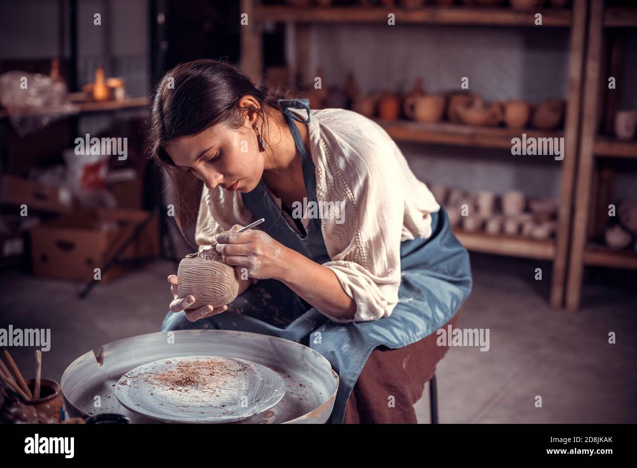 Stylish pottery woman shows how to work with clay and pottery wheel ...