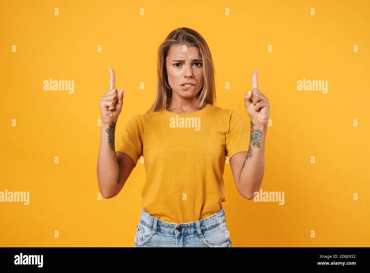 Image of blonde confused woman pointing fingers upward isolated over ...