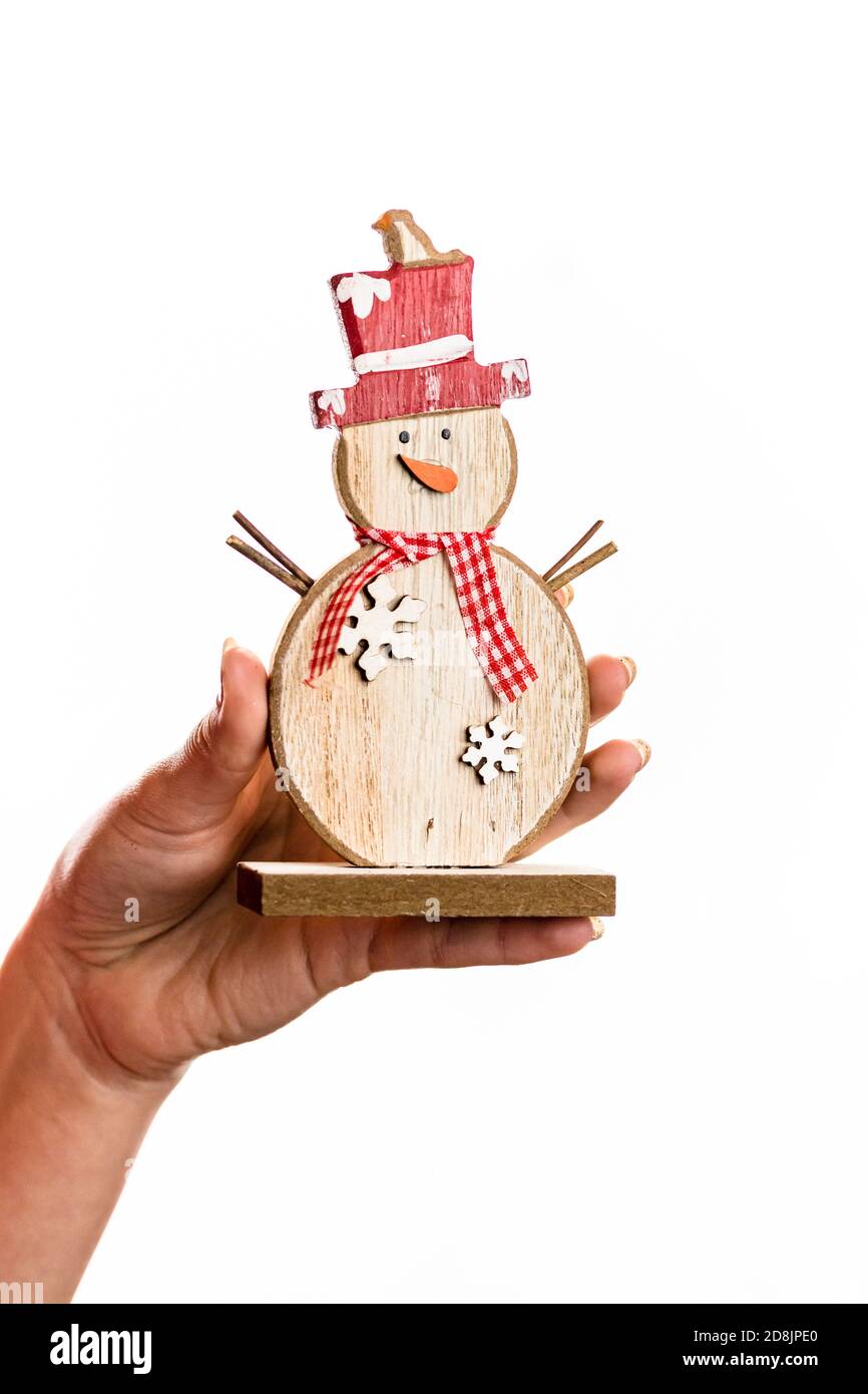 Hand holding Christmas snowman figurine isolated on white background ...