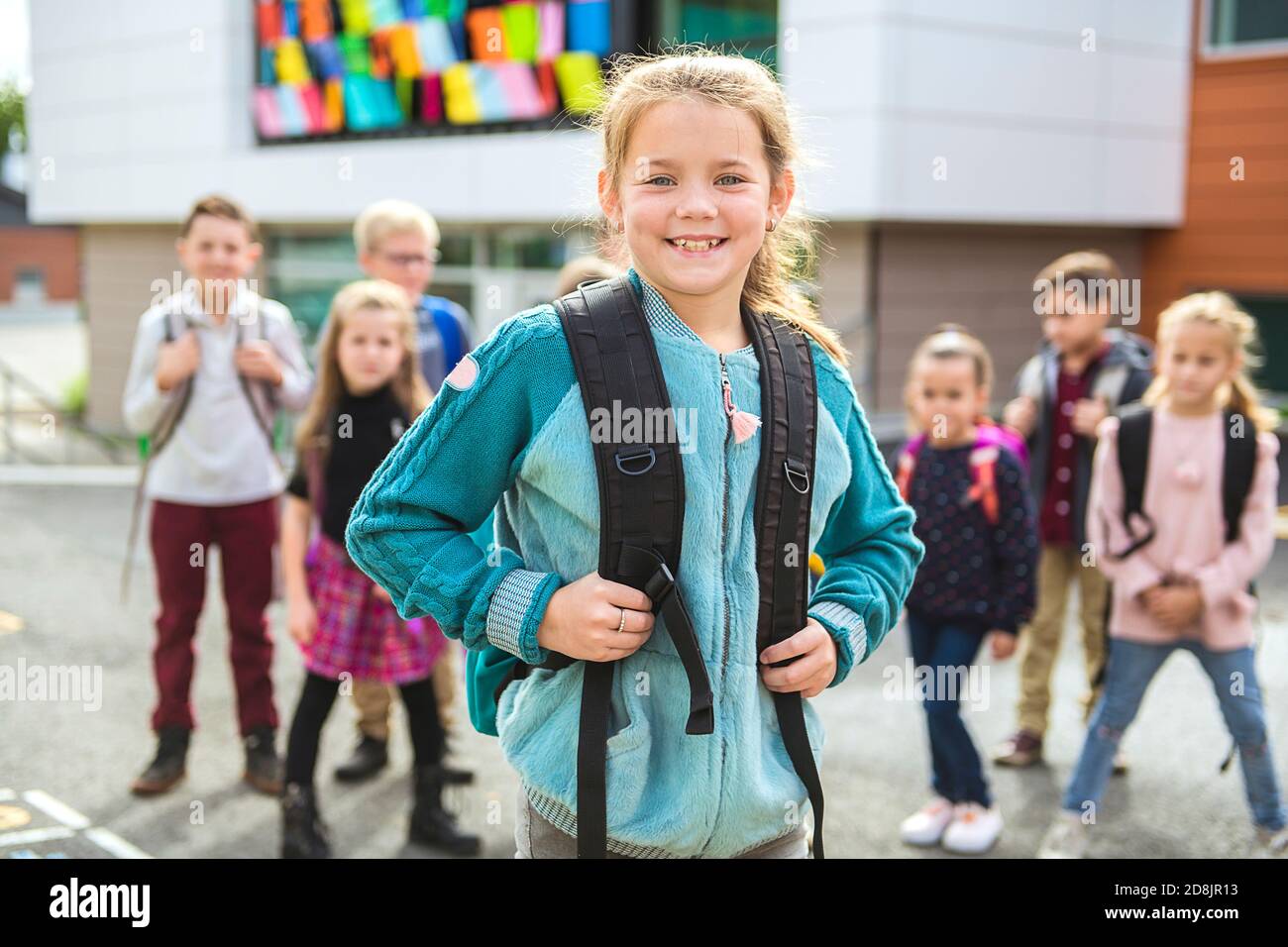A schoolgirl standing with other student on the back Stock Photo - Alamy