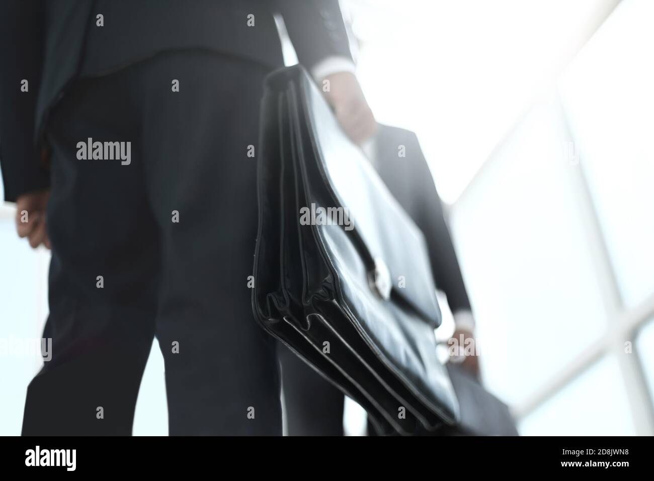 Business men in black suit hand holding briefcase Stock Photo - Alamy