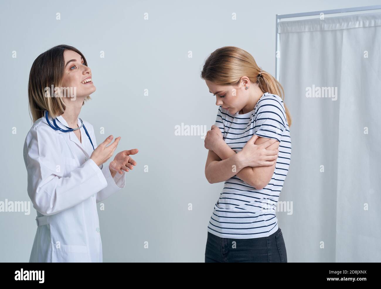 woman tells the doctor her health problems on a light background Stock ...