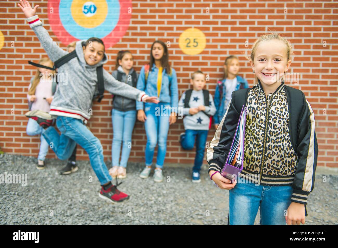 kid on the school background having fun with one student jump Stock ...