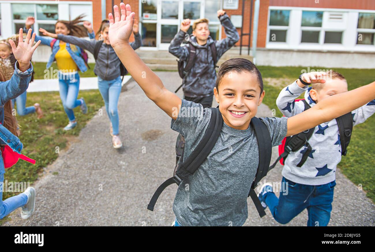 group of kids on the school background having fun at the end of class ...