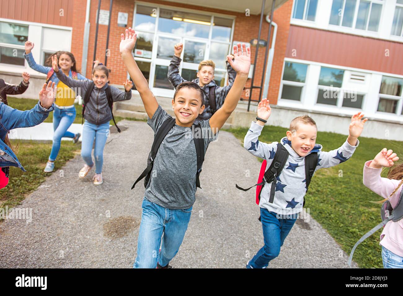group of kids on the school background having fun at the end of class ...