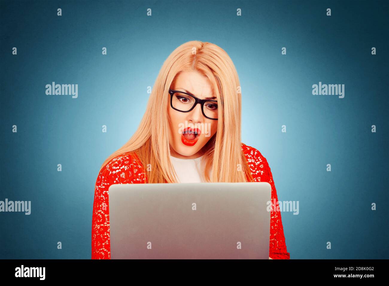 Wow, shocking news. Woman in shock looking at computer texting ...