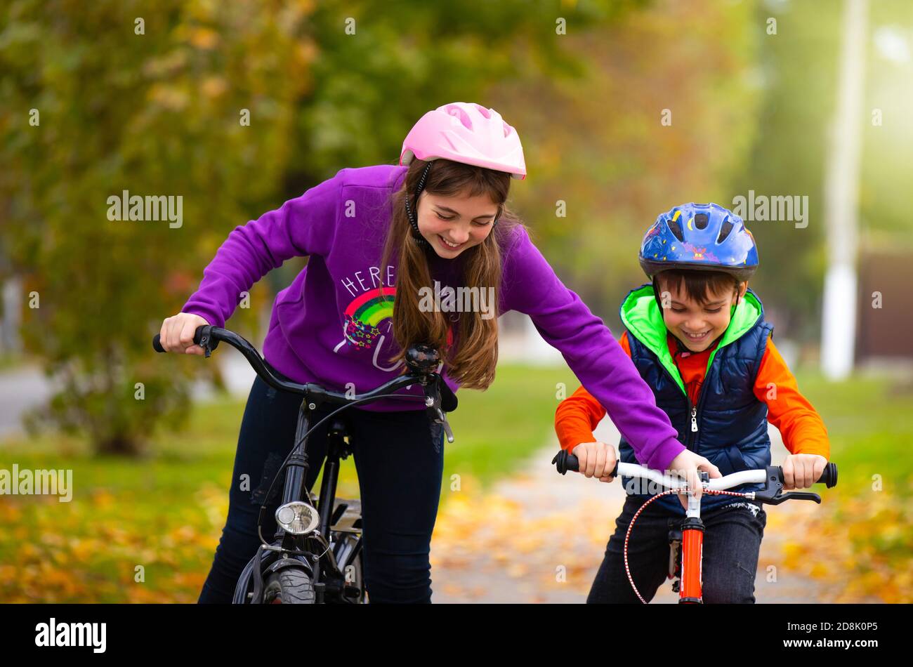 Children have fun. A sister teaches her little brother to ride a bike ...