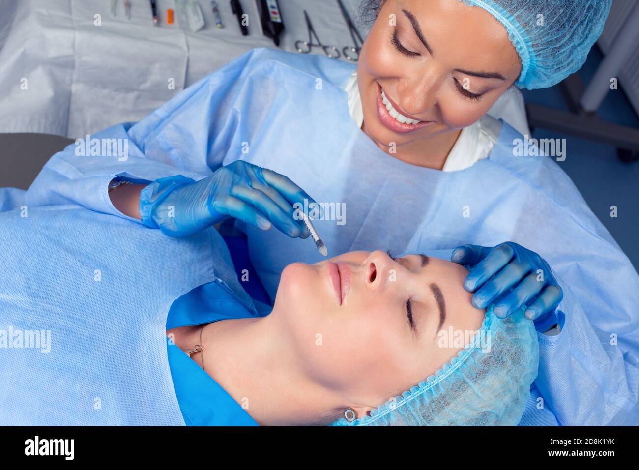 Pretty mature woman receiving cosmetic injection on her lips in a ...