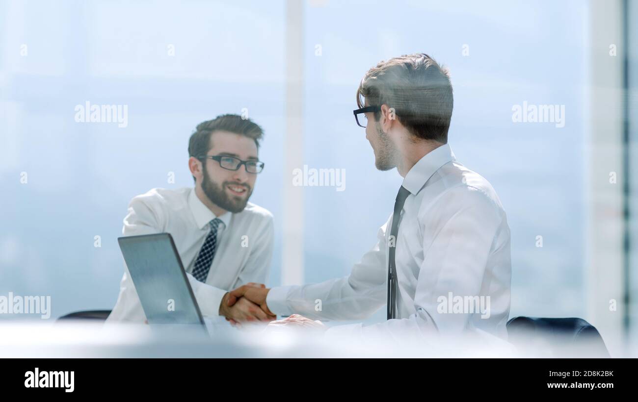 employees shaking hands at the Desk Stock Photo - Alamy