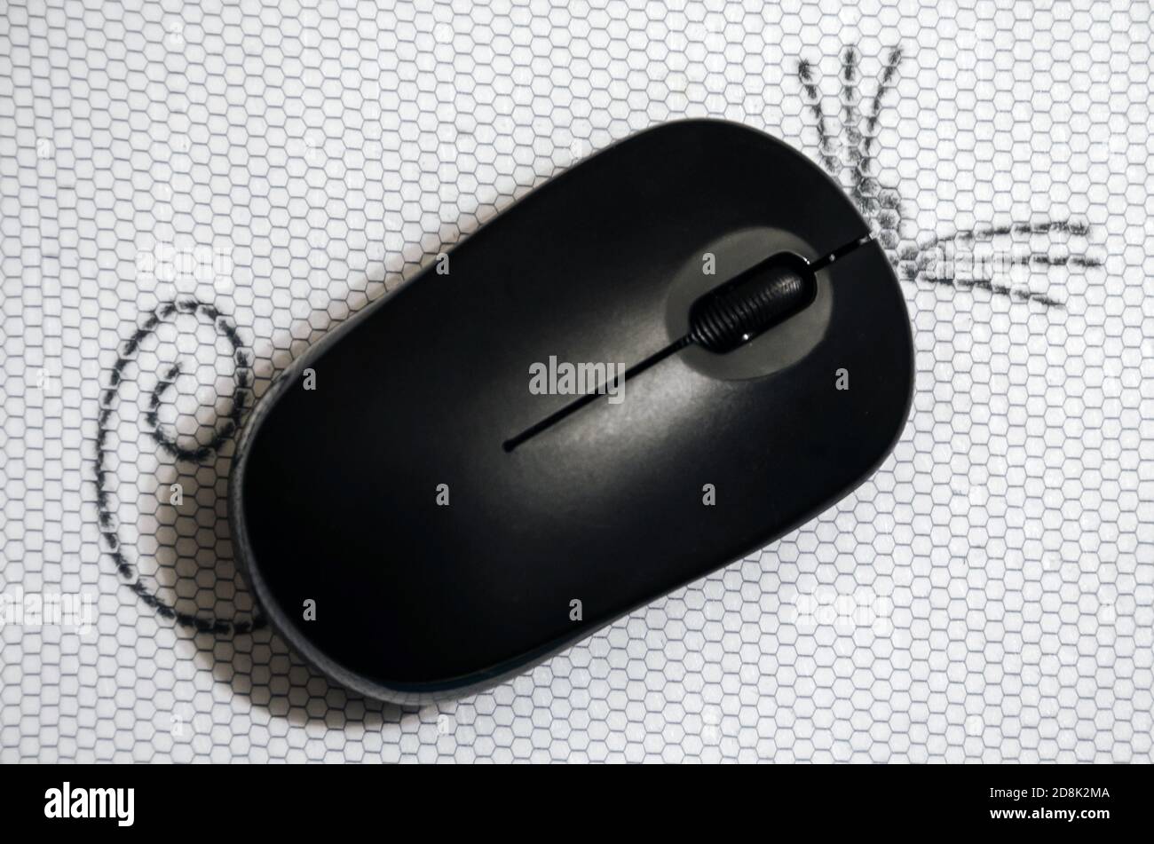 black computer mouse on a light background in a honeycomb with a tail ...