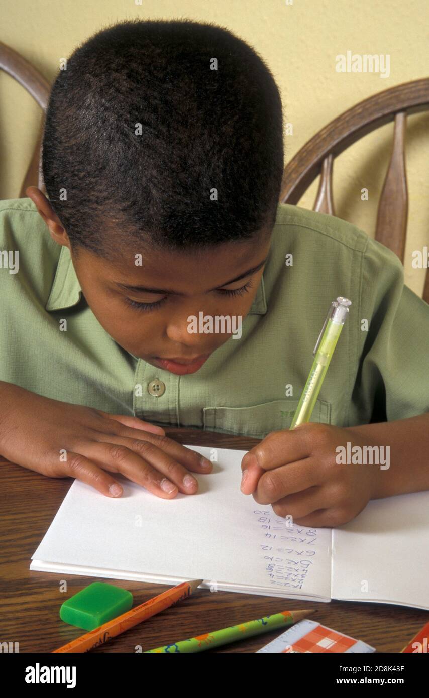young black boy writing out his times table Stock Photo - Alamy