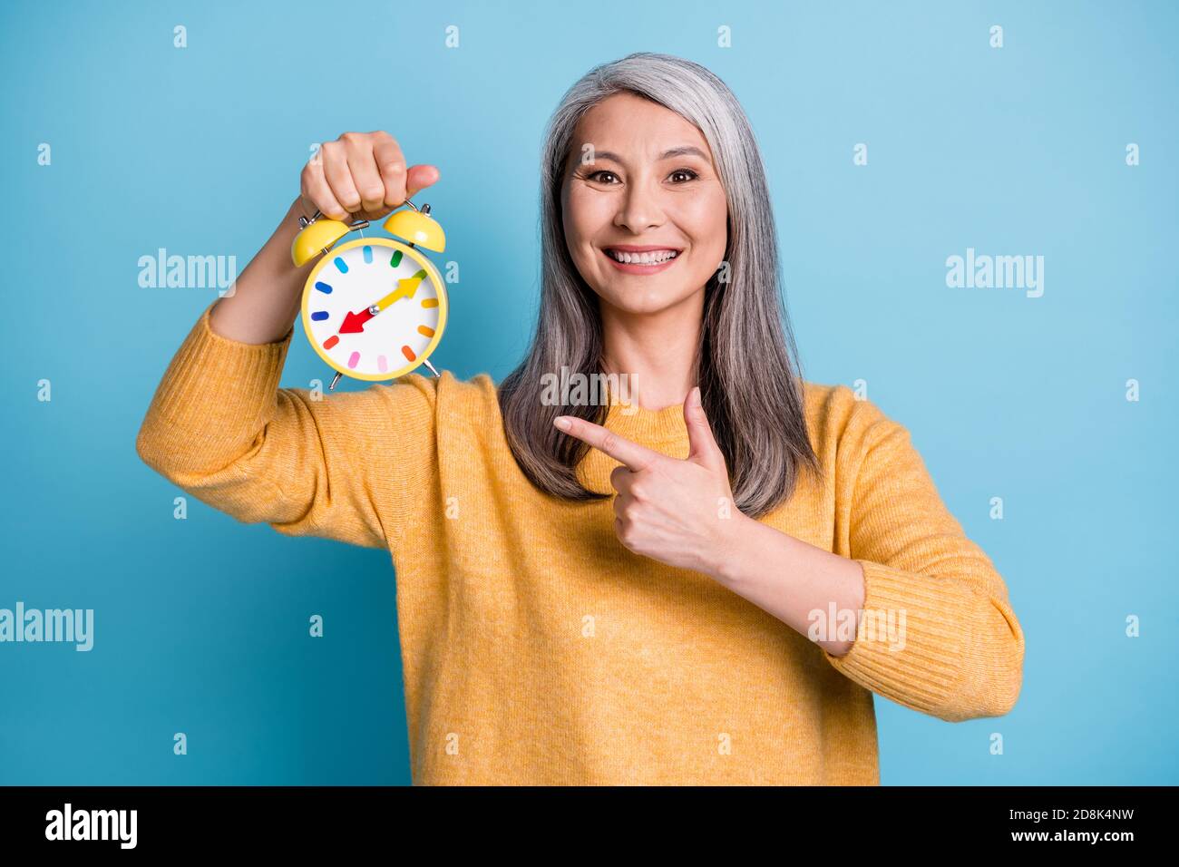 Photo if positive old woman hold clock point index finger time she ...