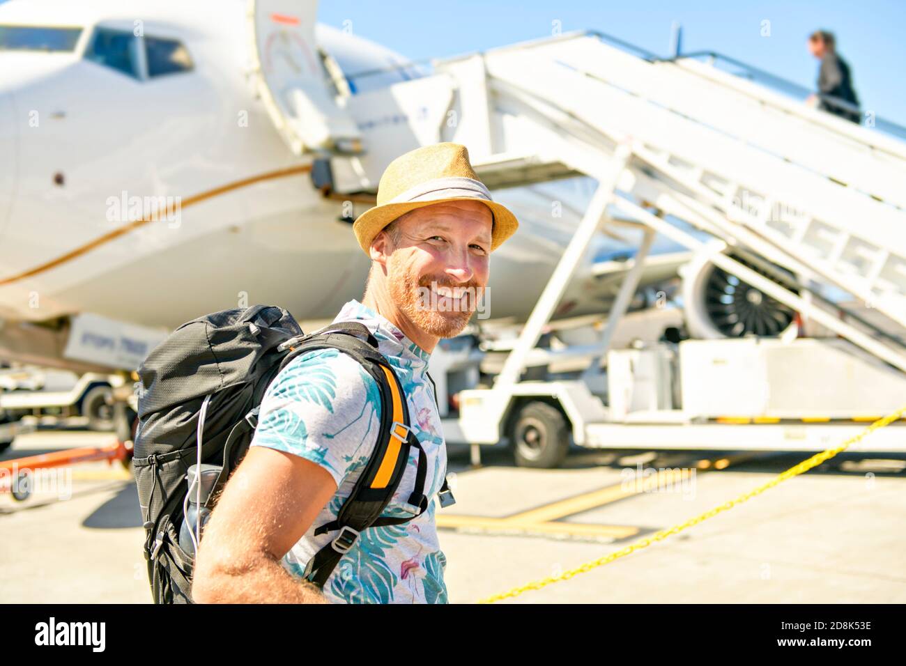 A Young traveling man get in the plane with passport on the landing ...