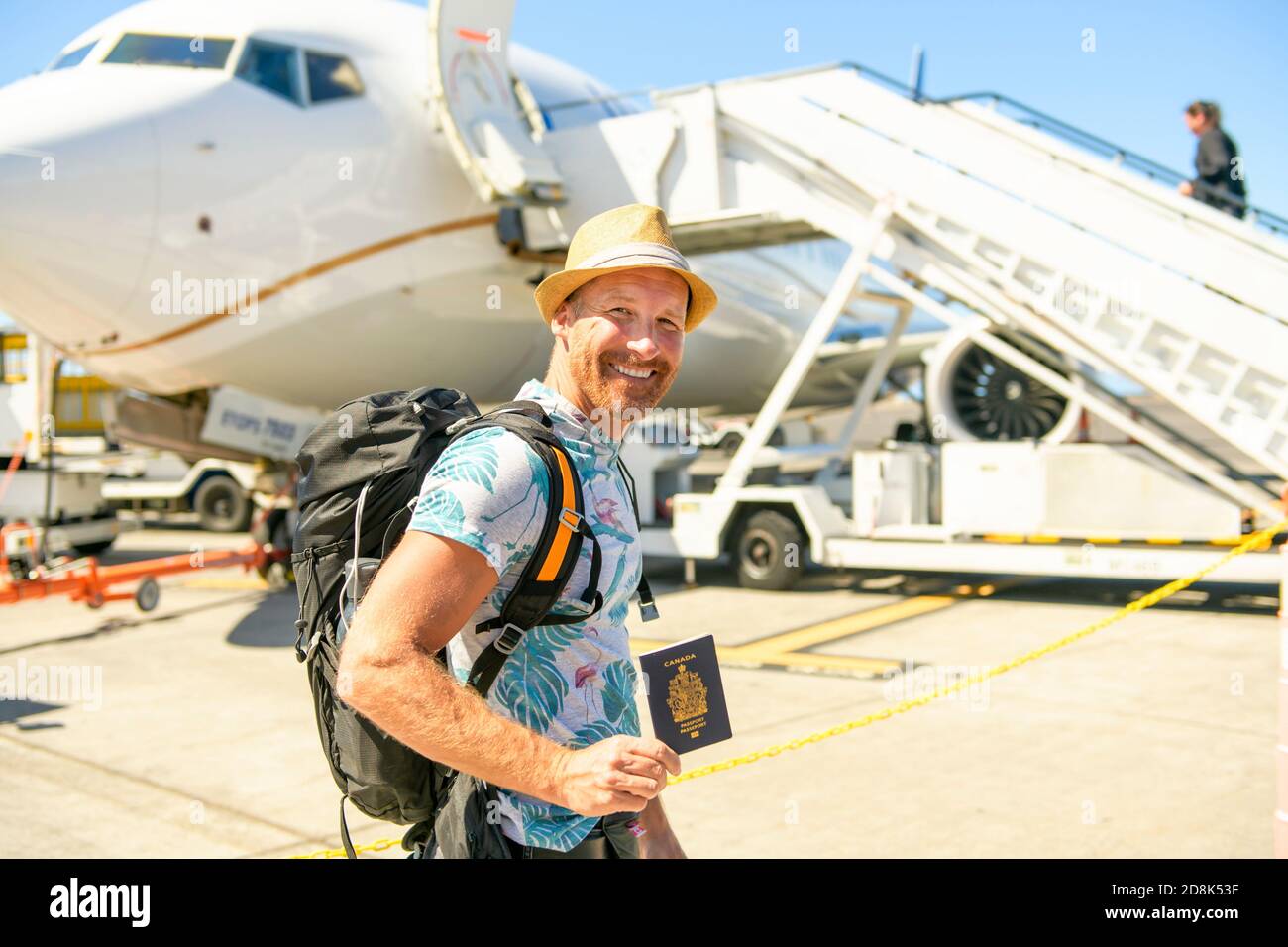 A Young traveling man get in the plane with passport on the landing ...