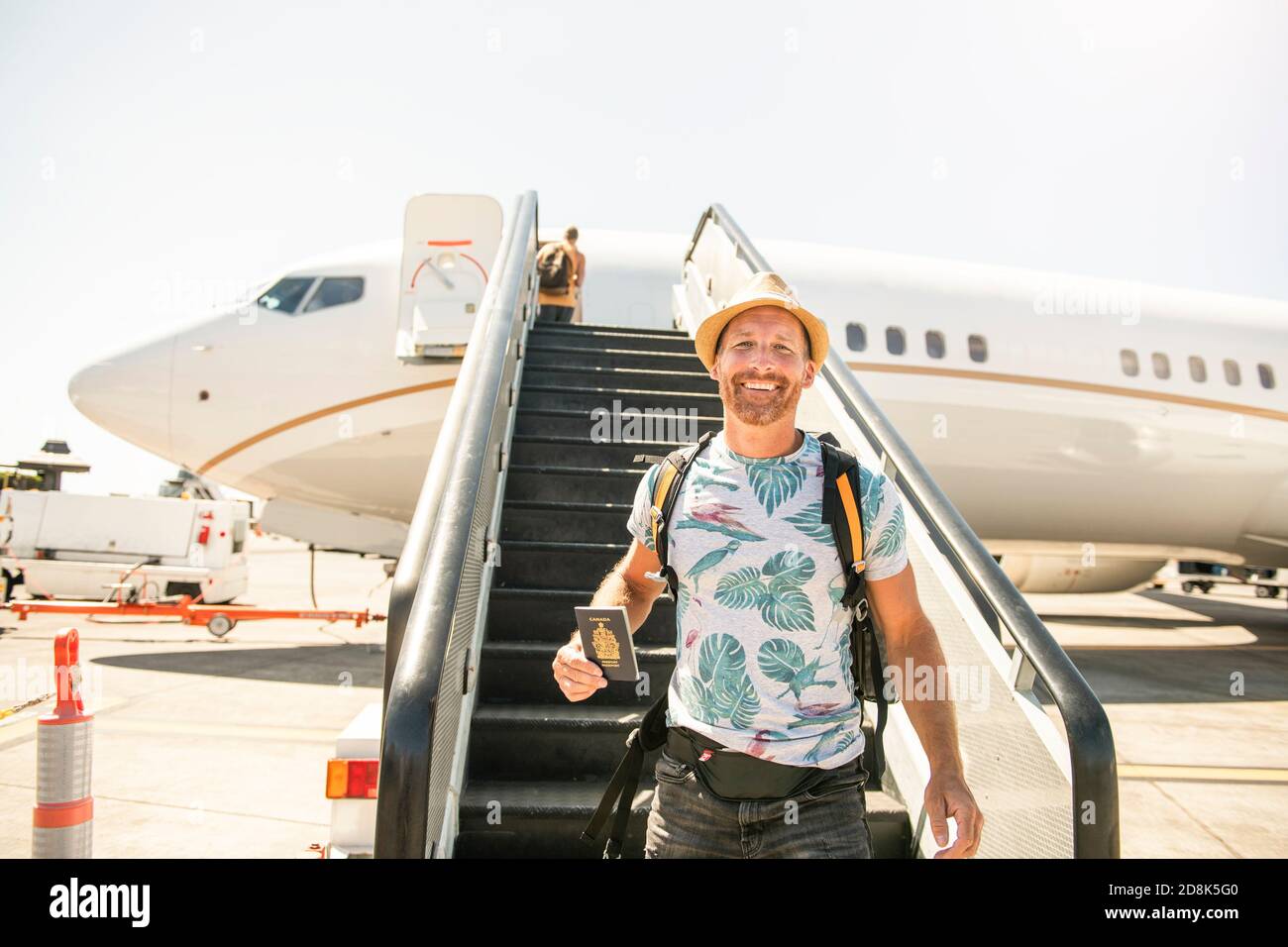 A Young traveling man get in the plane with passport on the landing ...