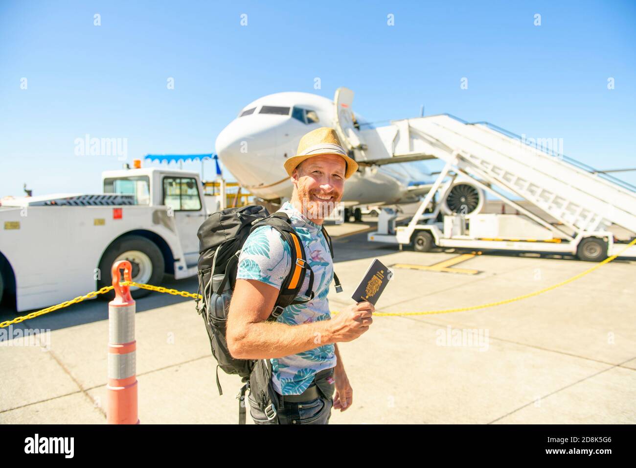 A Young traveling man get in the plane with passport on the landing ...