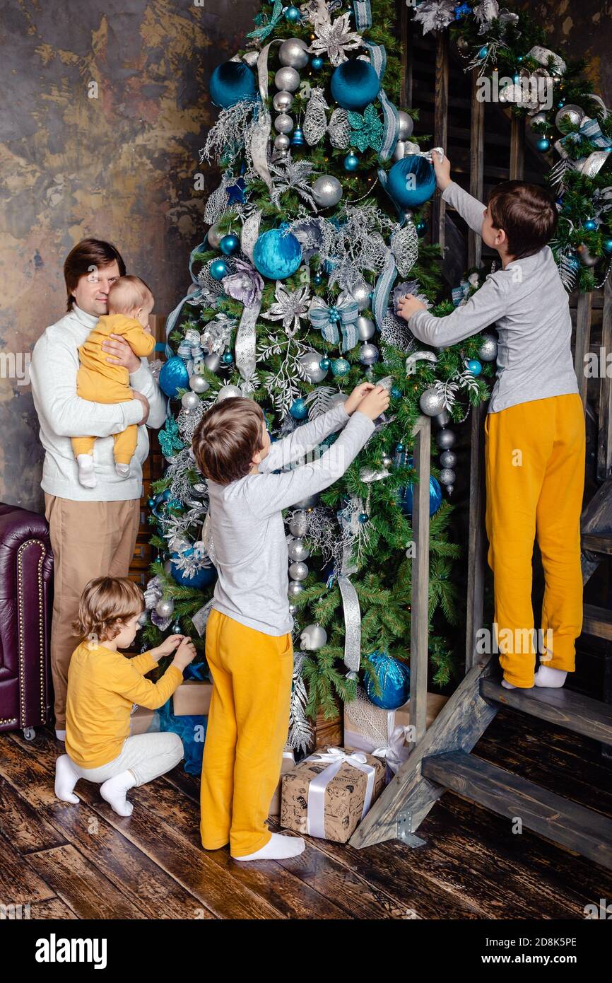Father with his sons decorate the Christmas tree at home. Family, x-mas ...