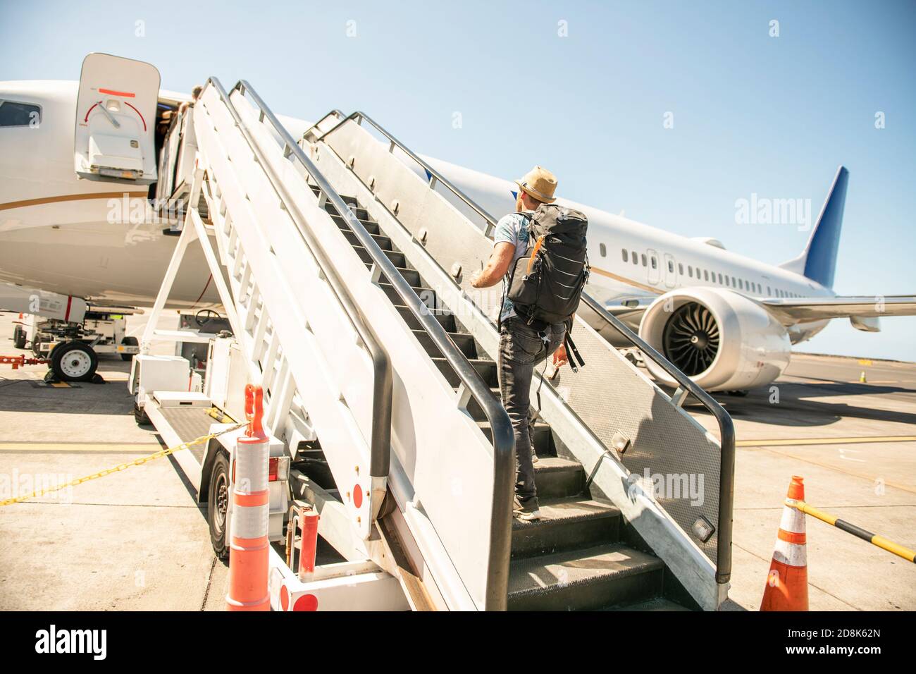 A Young traveling man get in the plane with passport on the landing ...