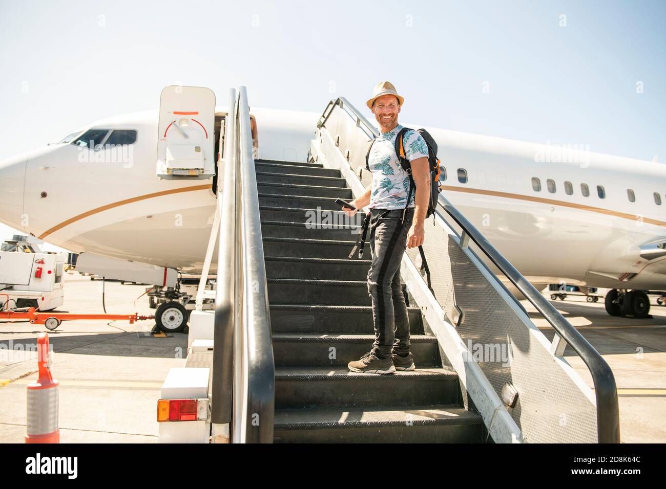 A Young traveling man get in the plane with passport on the landing ...