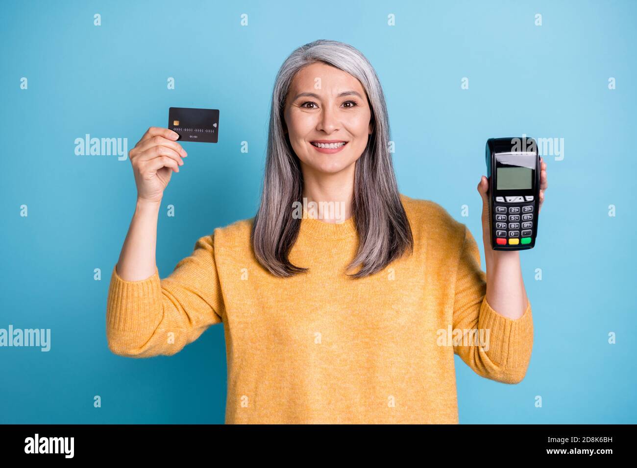 Photo of positive old lady hold demonstrate credit card pos terminal ...