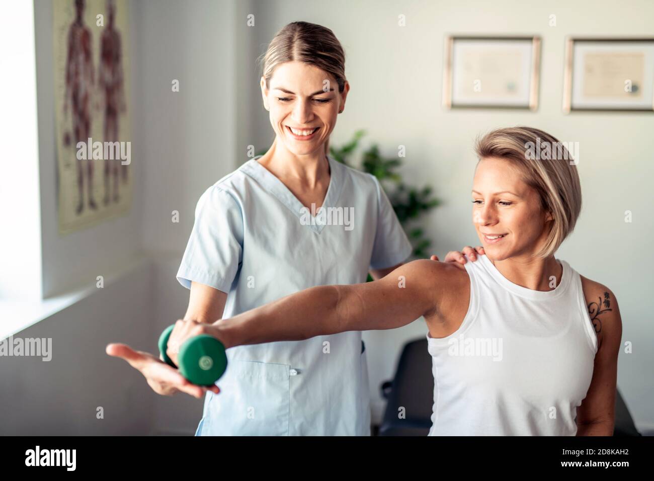 A Modern rehabilitation physiotherapy worker with woman client Stock ...