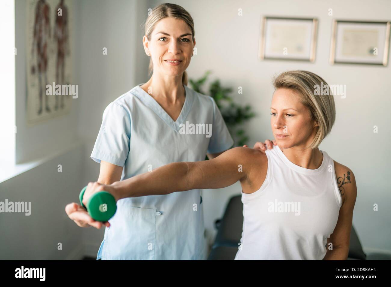 A Modern rehabilitation physiotherapy worker with woman client Stock ...