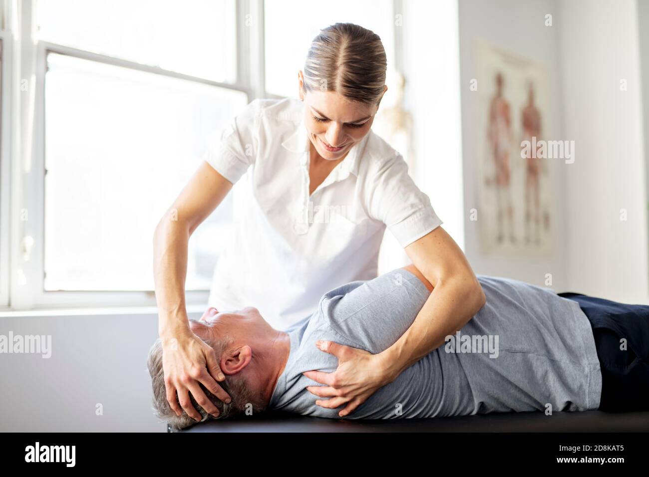 A Modern rehabilitation physiotherapy worker with senior client Stock ...