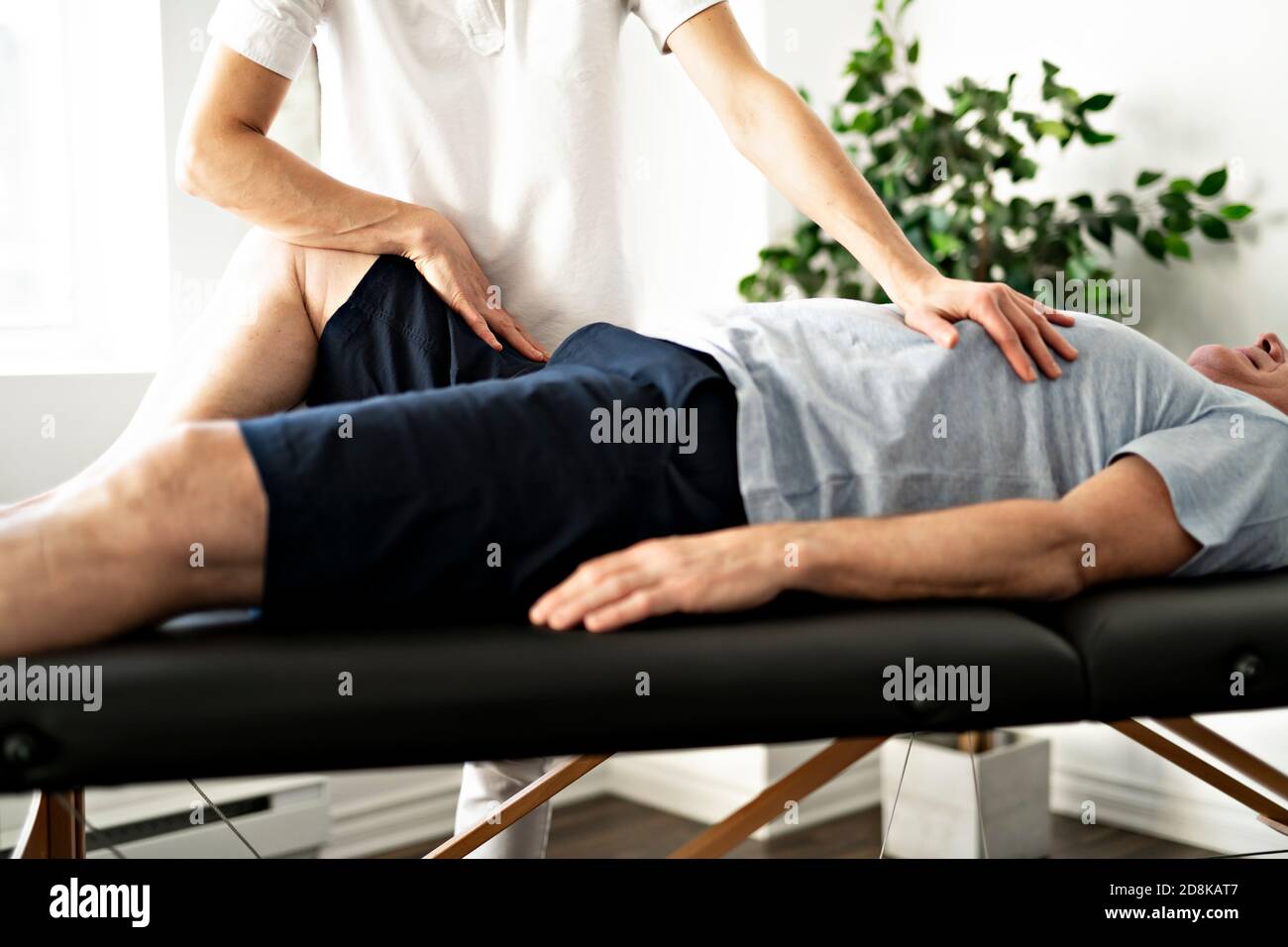 A Modern rehabilitation physiotherapy worker with senior client Stock ...